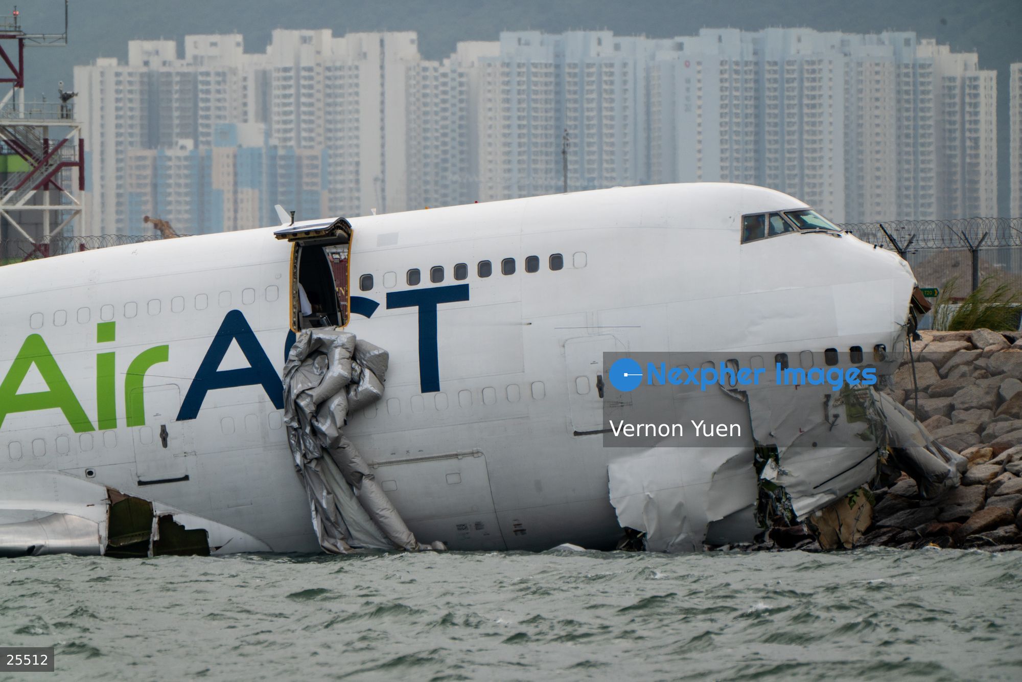 The front of a cargo plane lies partially in the sea after veering ...